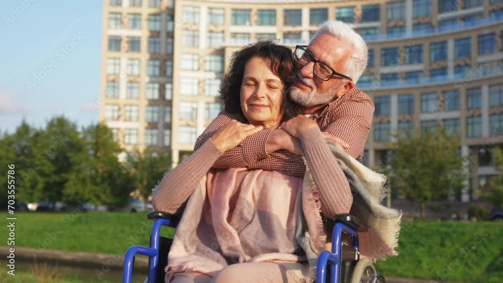 Senior handicap woman in wheelchair walking with caregiver old man on ...