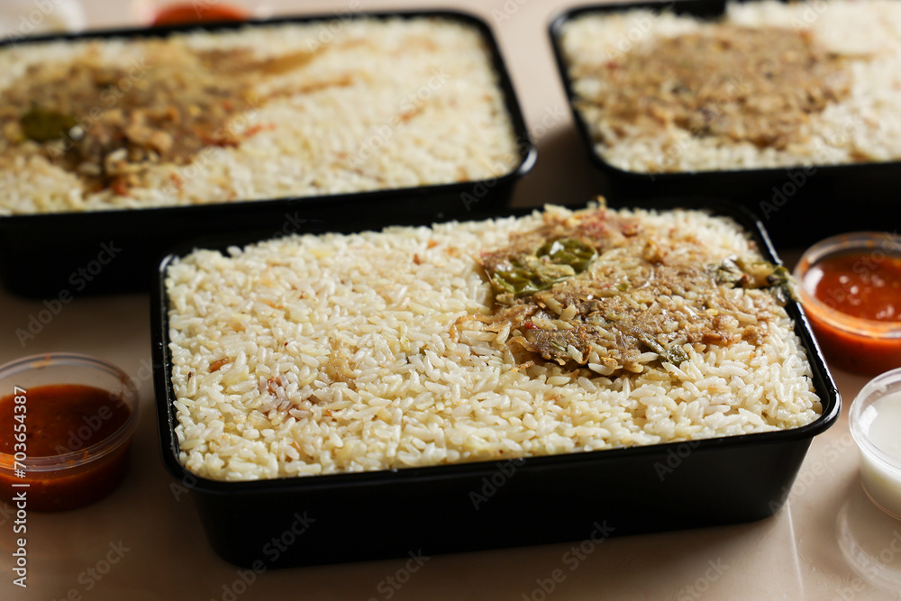 Women hand eating Mutton biryani. Packed box take away Chicken biryani ...