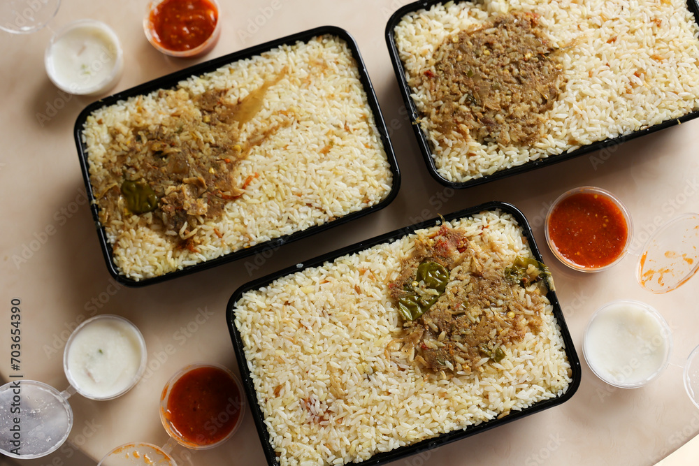 Women hand eating Mutton biryani. Packed box take away Chicken biryani ...