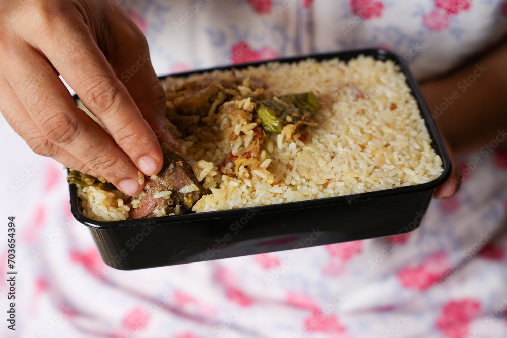 Women hand eating Mutton biryani. Packed box take away Chicken biryani ...