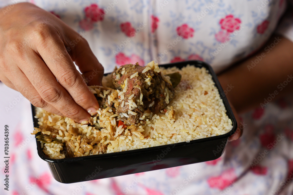 Women hand eating Mutton biryani. Packed box take away Chicken biryani ...