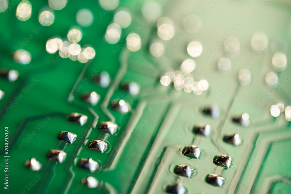 Conductor traces with silver drops of solder on a green electronic ...