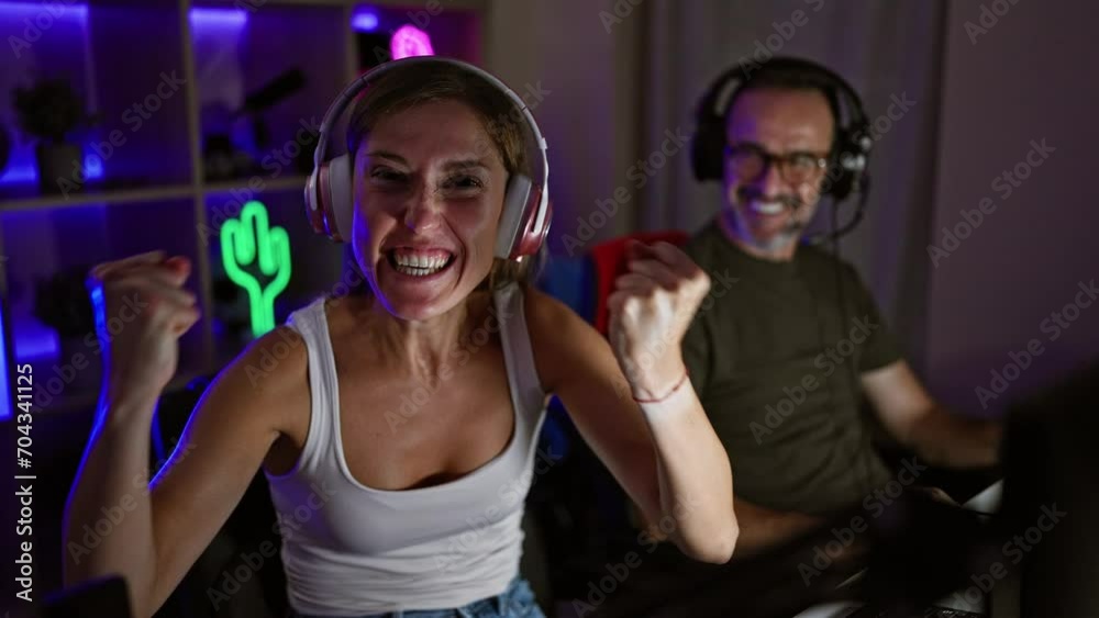 Two ecstatic workers celebrating video game win together in a buzzing ...