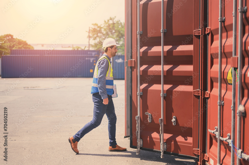 container logistic operators wearing helmets and reflection shirts walk ...