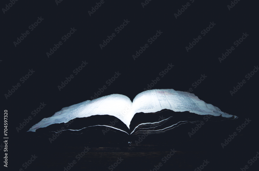 The unfolded book of the Holy Bible. Ancient book in the dark. Open ...