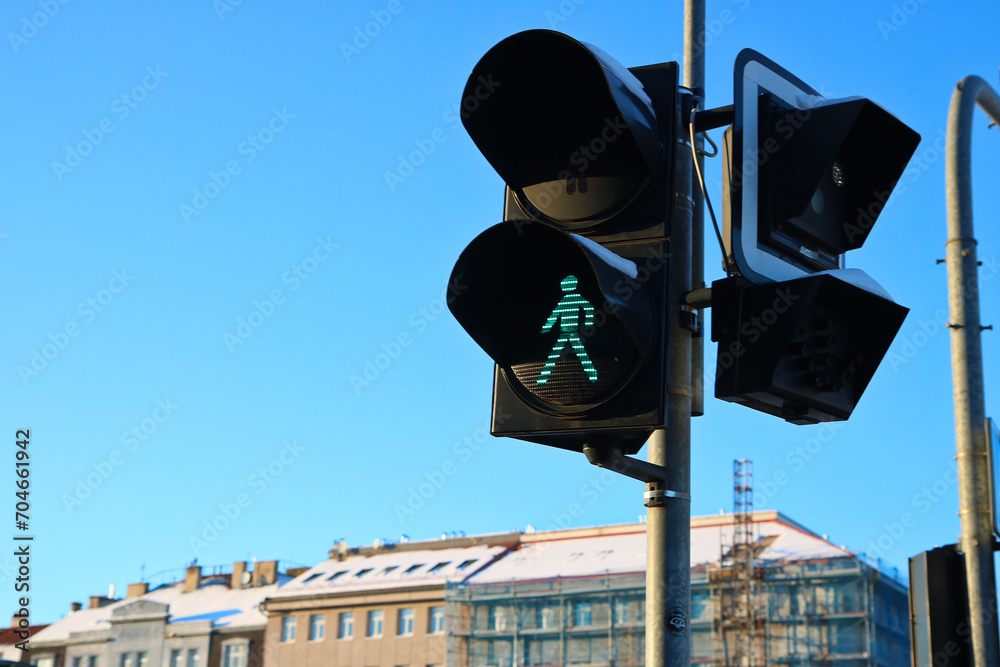 Pedestrian traffic light with green stick figure symbol, winter city ...
