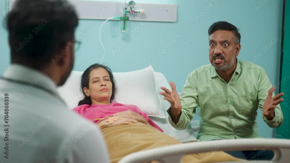 Shoulder shot, angry patient husband scolding or arguing with doctor at ...