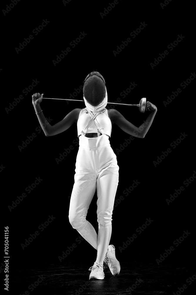 Portrait of swordswoman posing with her dual blades resting on her ...