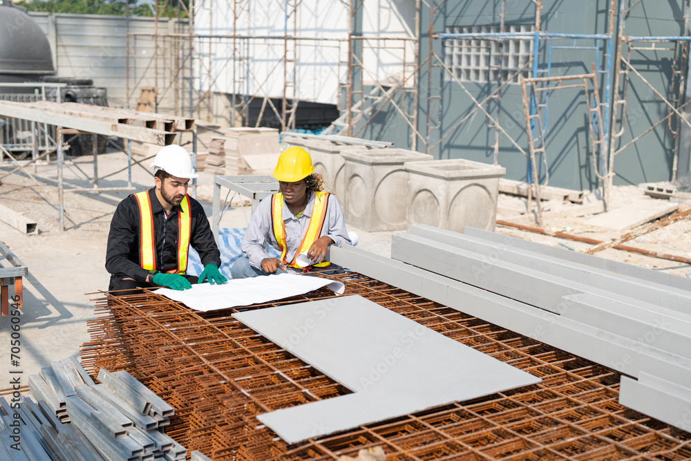 Man engineer and African American woman architect checking steel ...