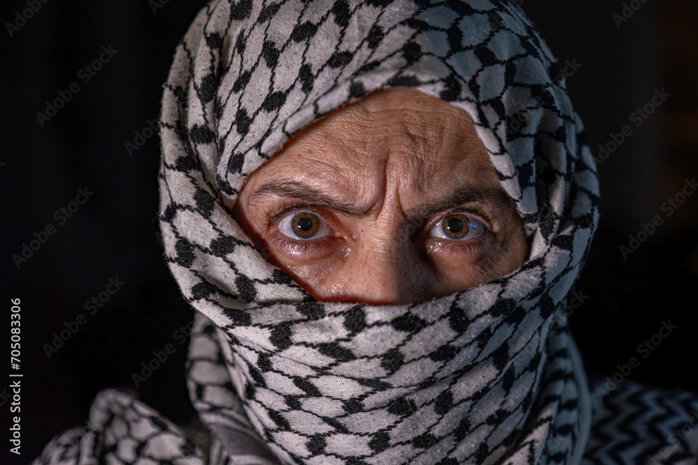 portrait of pearson wearing white keffiyeh on dark background with ...