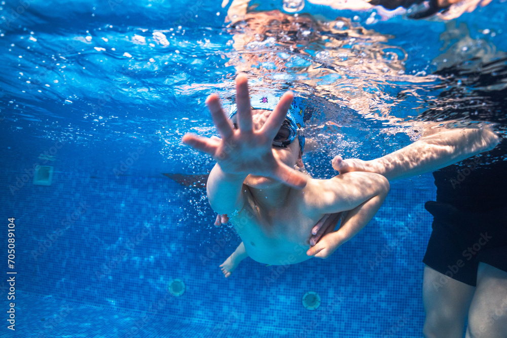 Little child swims underwater in swimming pool, happy active dives and ...