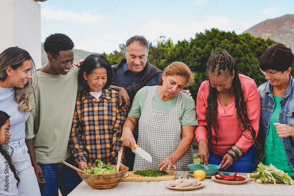 Happy multi generational people having fun preparing barbecue dinner ...