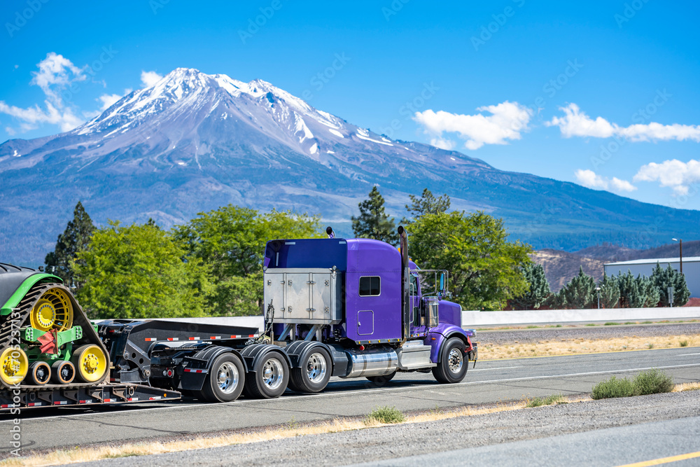 Bright purple powerful classic big rig semi truck tractor with three ...