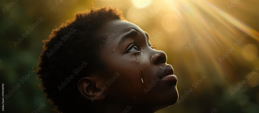 Touched by His Grace. Beautiful young black woman looking up with tears ...