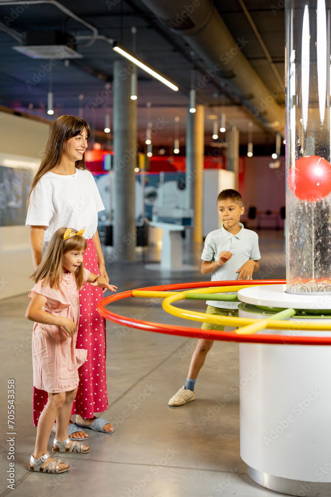 Mom with kids learn physics interactively on a model that shows ...
