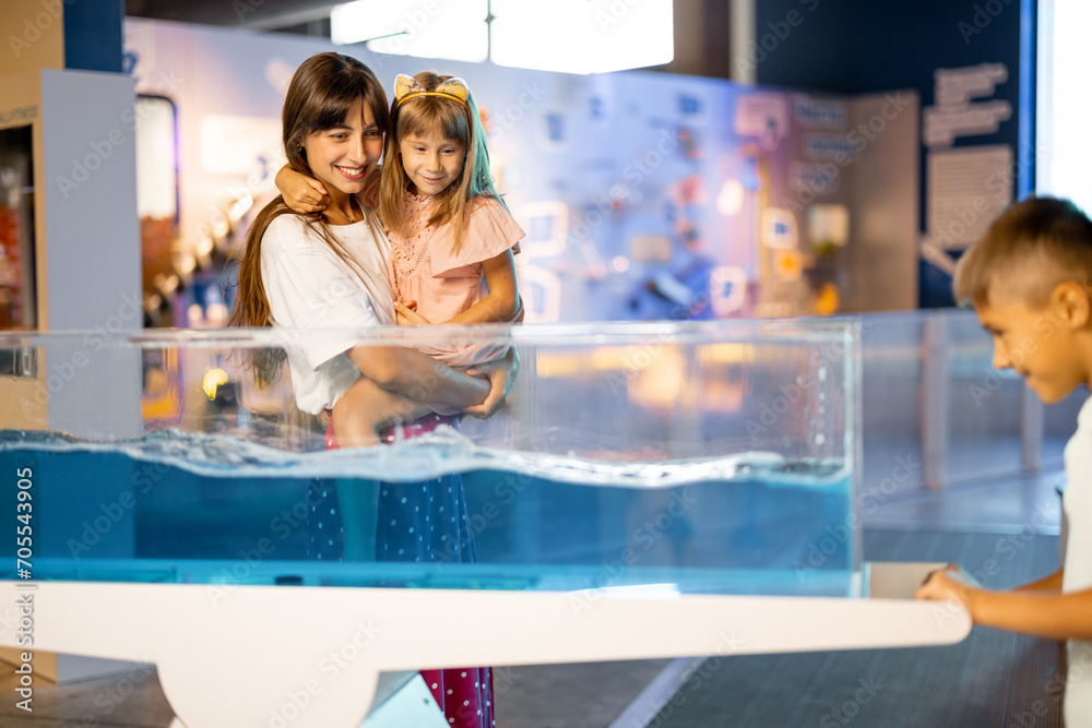 Mom with kids learn physics interactively on a model that shows ...