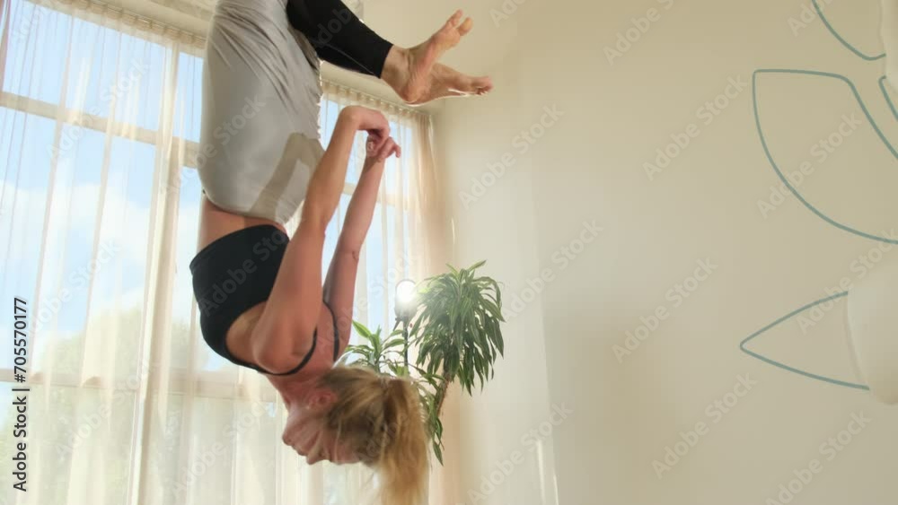 Vidéo Stock Woman stretches back hanging upside down on aerial yoga ...