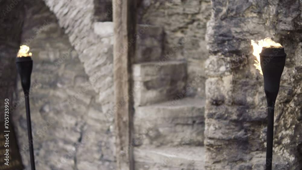 Two torches burn before a medieval palace. Flame of cressets at the ...