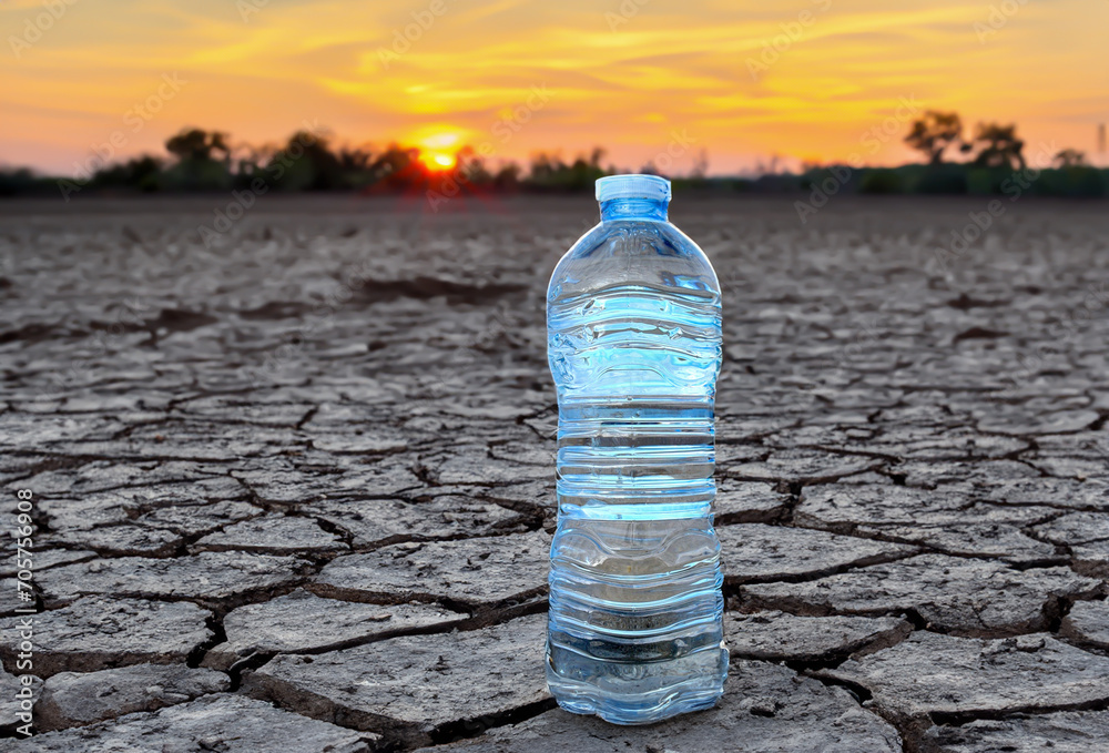 Mineral water on Drought land. Global drought. Plastic bottle with ...