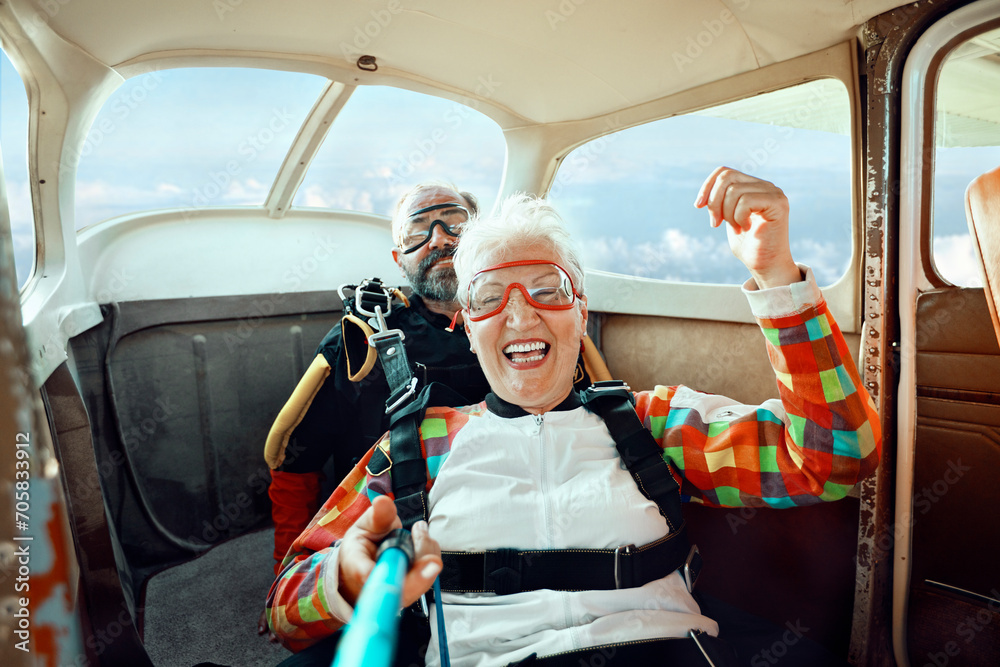 Senior woman skydiving with instructor in airplane Stock Photo | Adobe ...