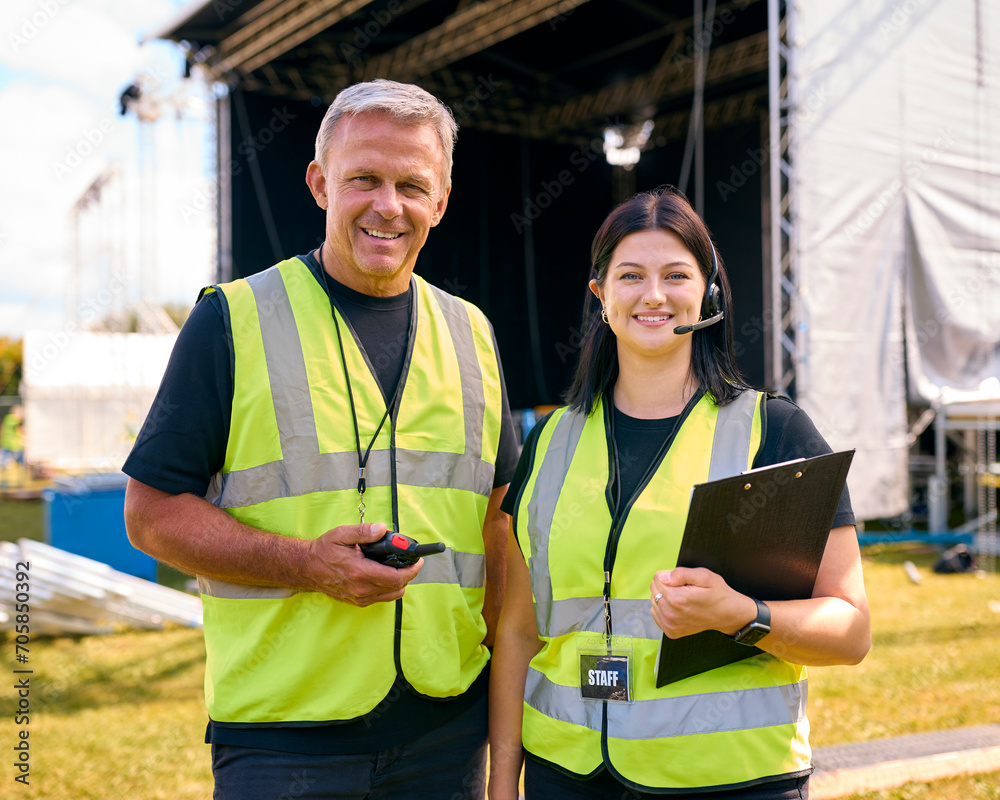 Portrait Of Production Team With Headsets Setting Up Outdoor Stage For ...