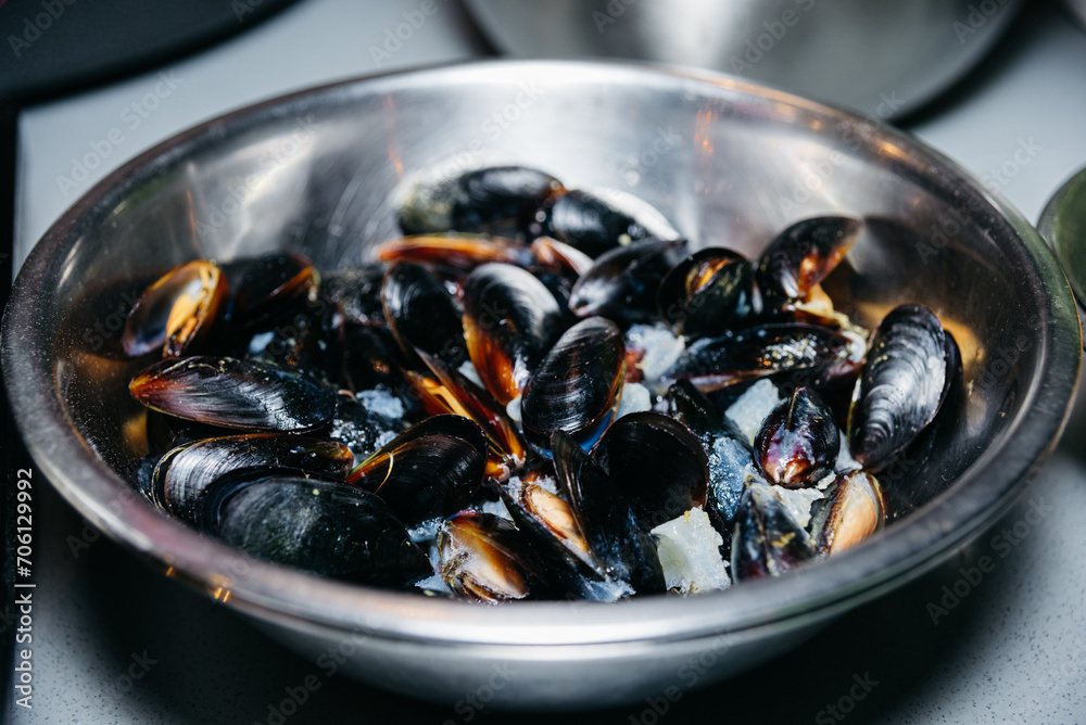 Open Shell Mussels Defrosting in Metal Bowl. A metal bowl containing ...