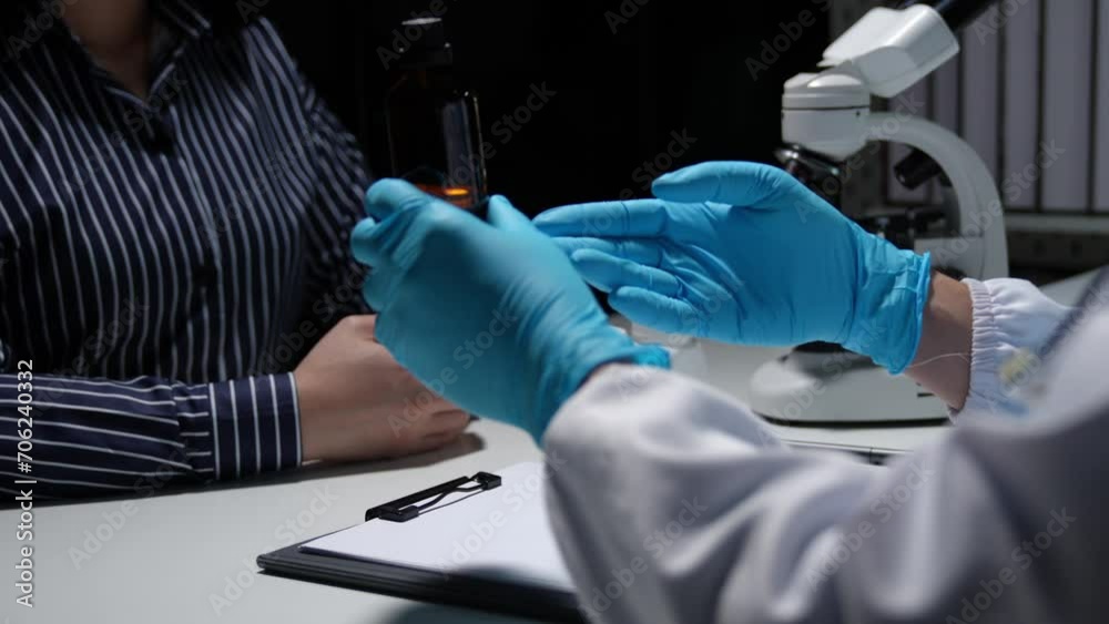 Medical development laboratory, scientists wearing gloves under a ...