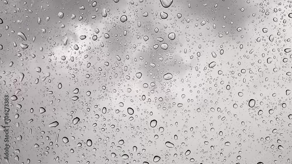 Raindrops flow downwards. Rain water splashed all over the glass ...