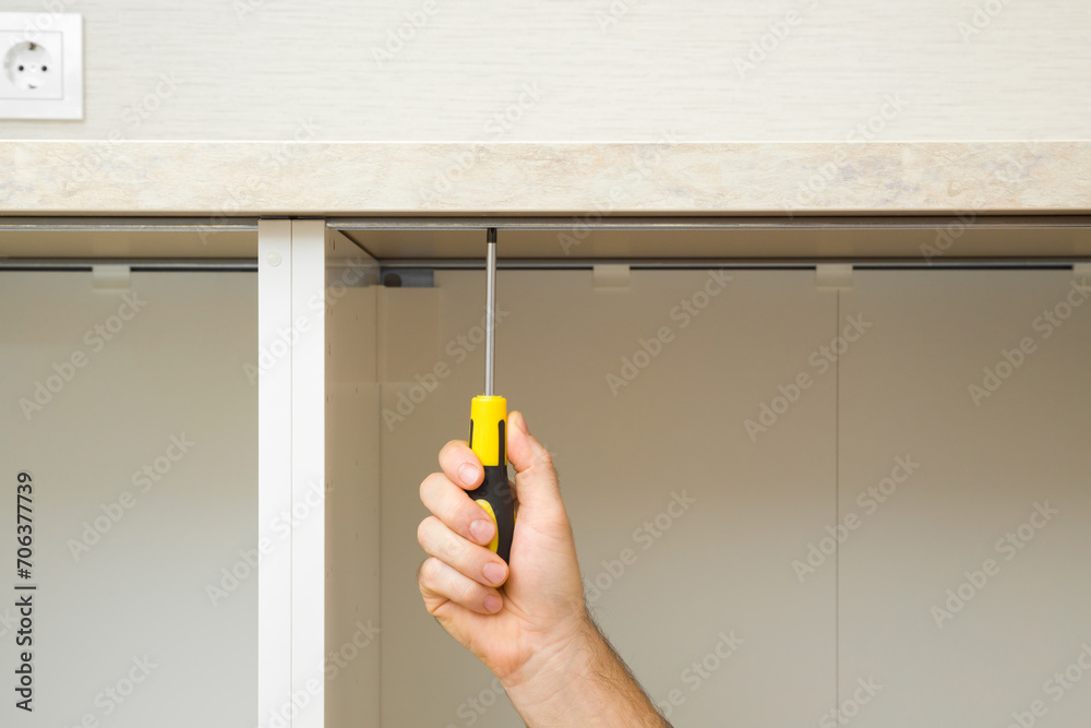 Young adult man hand using manual screwdriver and screwing screw in ...