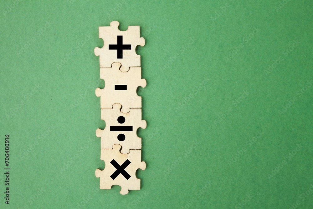 wooden puzzle with plus, minus, division and multiplication signs ...