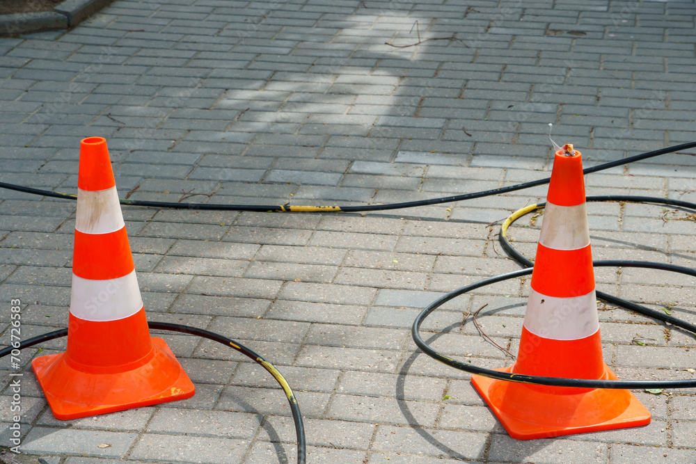 Orange cones installed around the dangerous area on the sidewalk. An ...