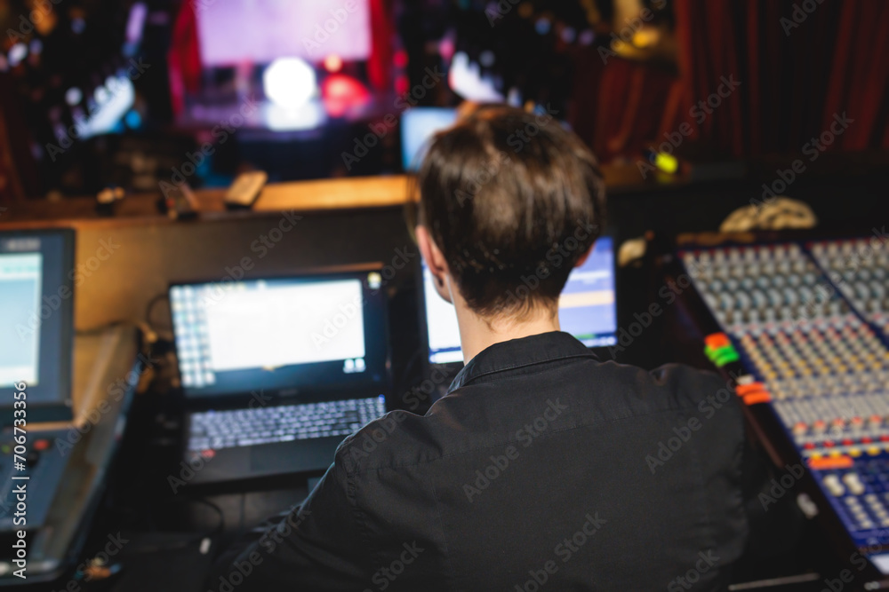View of lighting technician operator working on mixing console ...