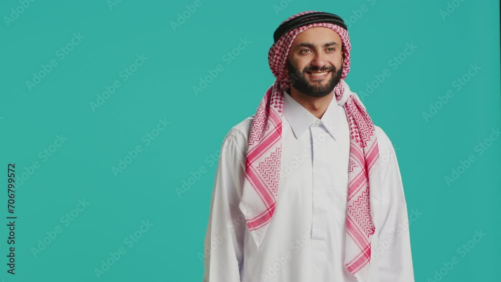 Middle eastern guy in traditional wear, beaming and standing proudly ...