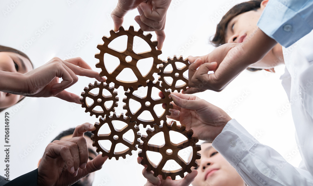 Below view office worker holding cog wheel as unity and teamwork in ...