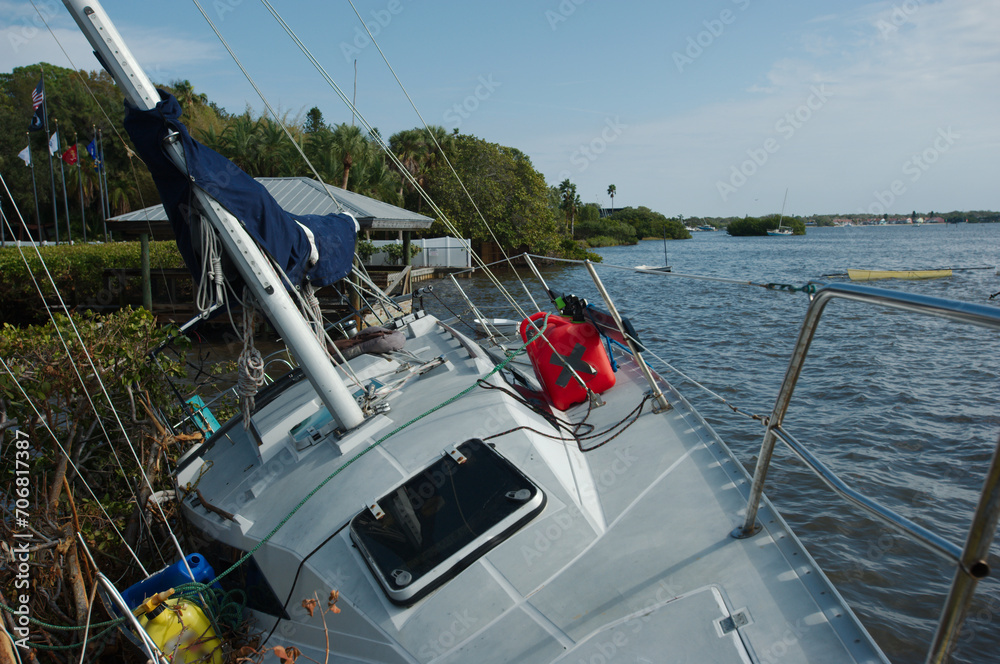 Close up Damaged Blue and gray Sailboat leaning to the left on the ...