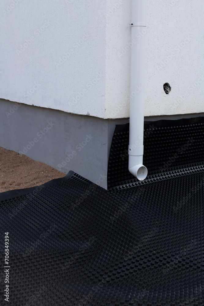 Black waterproofing membrane around the foundation of the house ...