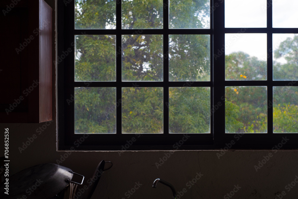 Ventana al exterior, con arboles verdes visibles. Cocina oscura. Stock ...