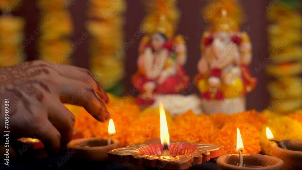 Indian woman hand placing diya in front of Hindu Gods - Diwali idol ...