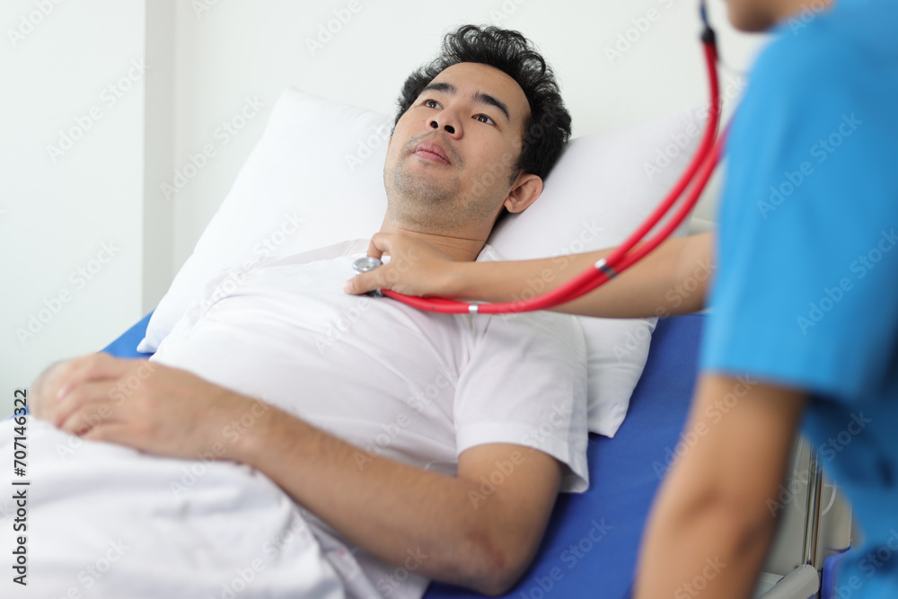 Doctor visiting a male patient on a hospital bed, Examine the patient ...