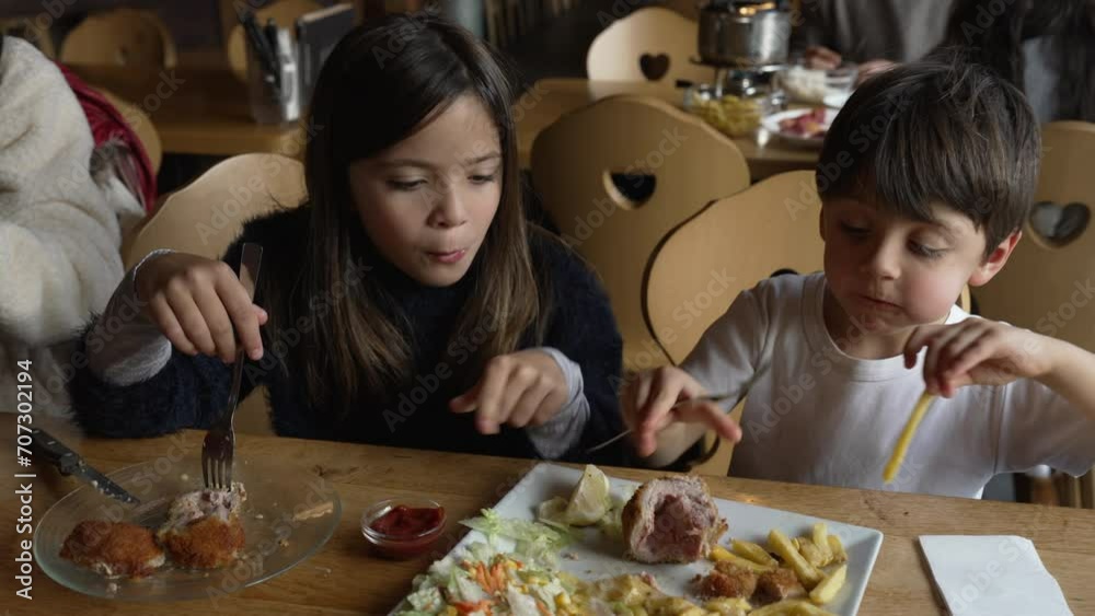 Vidéo Stock children enjoying mealtime at restaurant - small siblings ...