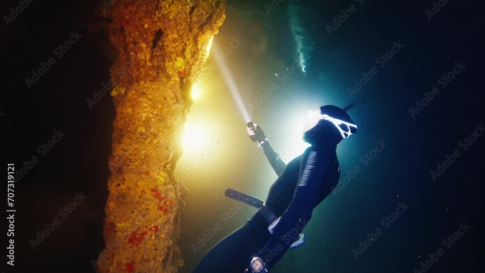 Cave freediving. Freediver swims underwater and explores intricate ...