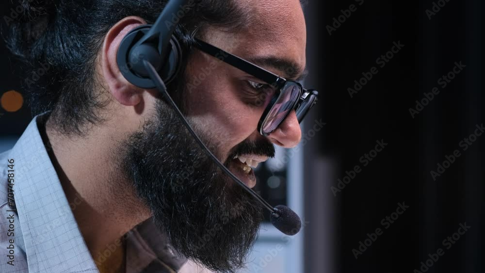 In the evening office, a close up portrait features a positive indian ...