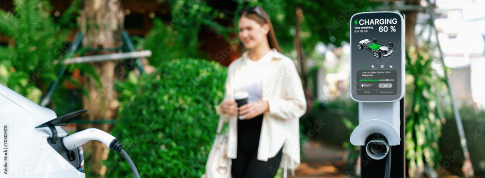 Young woman with coffee cup and sustainable urban commute with EV ...