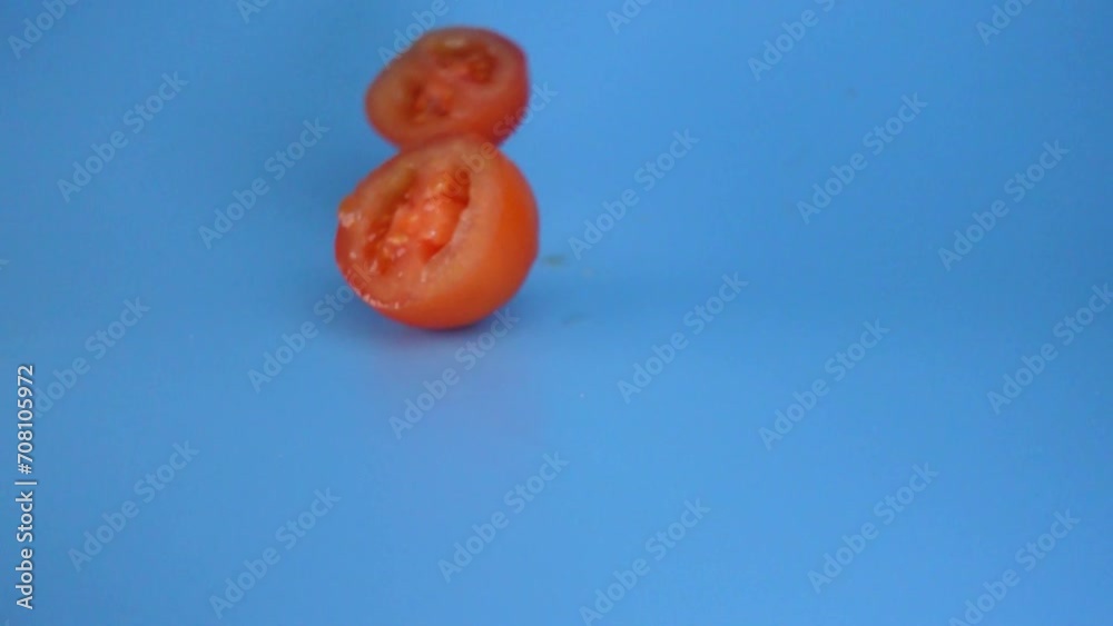 Two falling half cherry tomatoes in slow motion. High frame rate slow ...