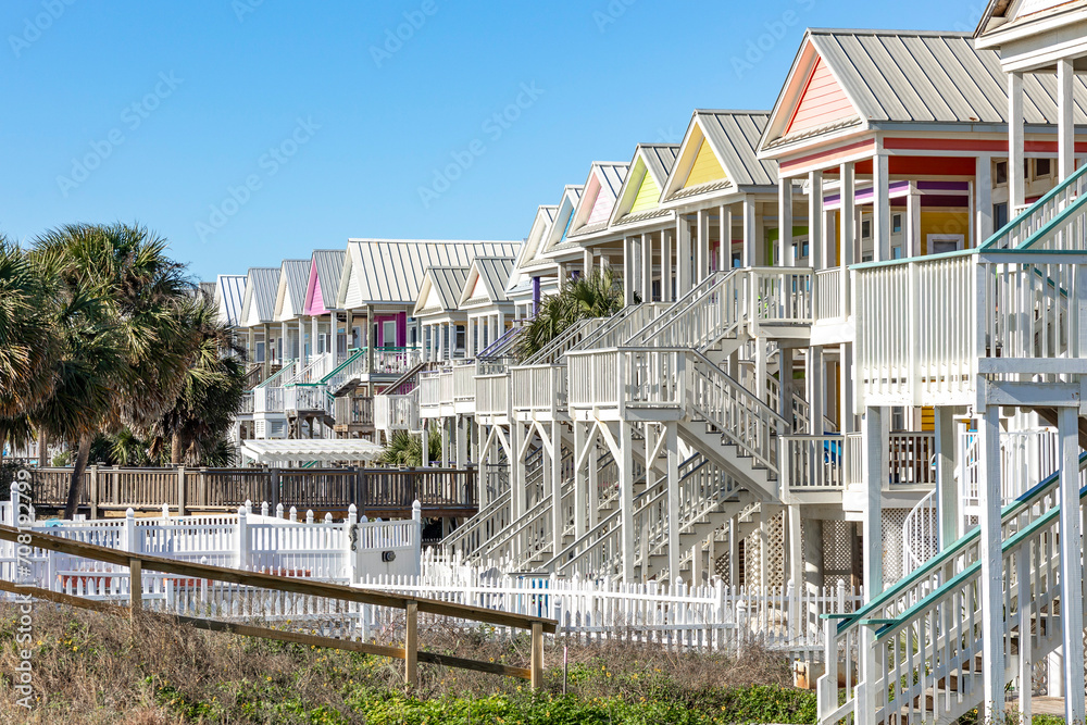Row of narrow beach houses with steps and decks in pastel colors. Stock ...