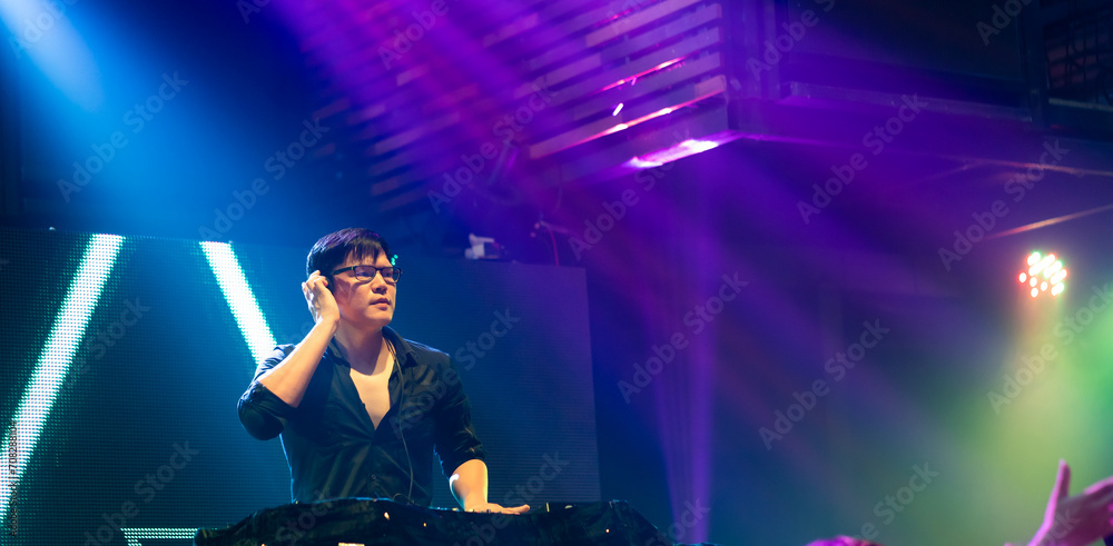 DJ with Turntables at nightclub. Group of diverse young people dancing ...