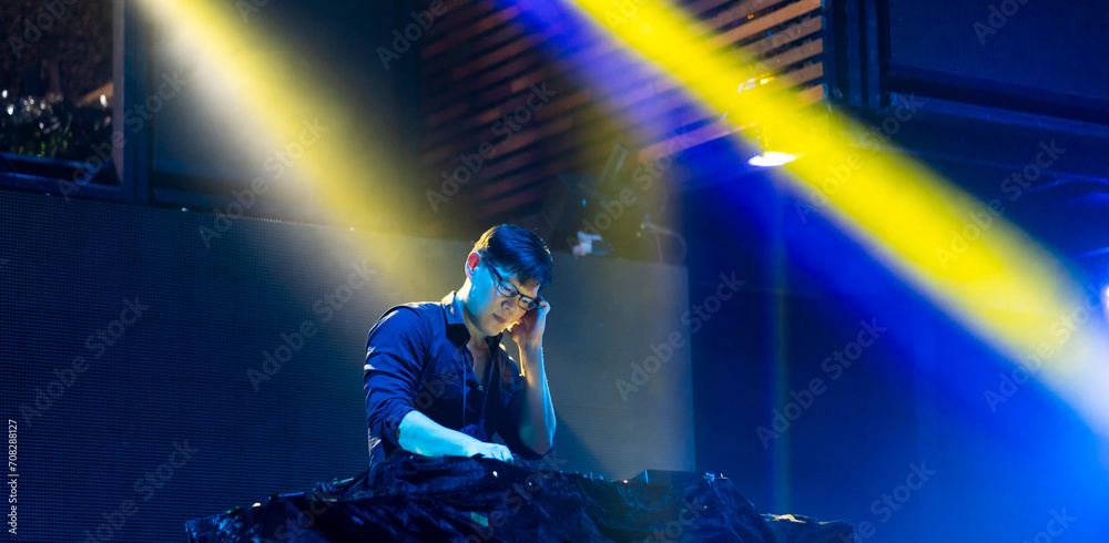 DJ with Turntables at nightclub. Group of diverse young people dancing ...