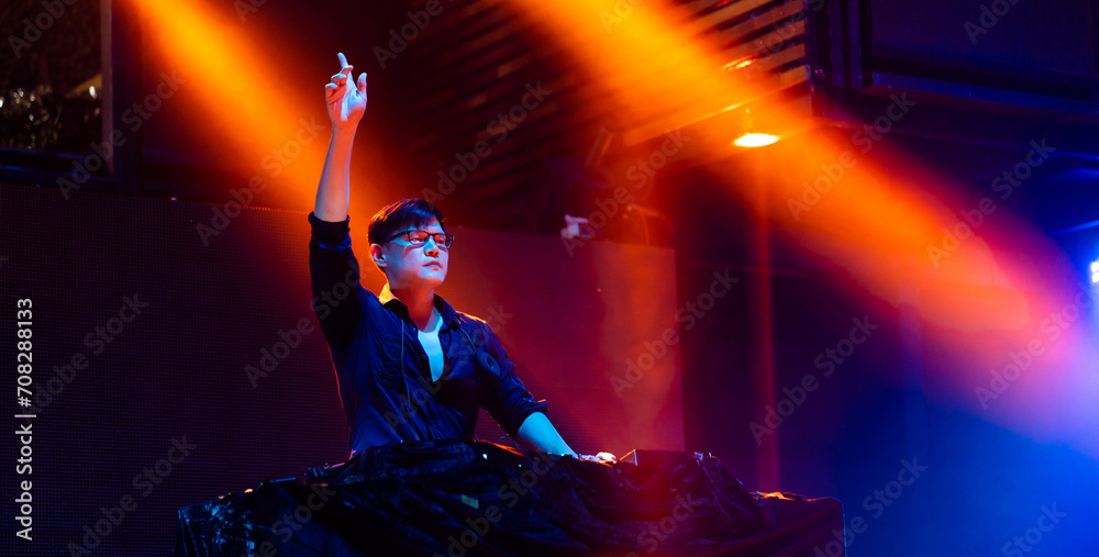 DJ with Turntables at nightclub. Group of diverse young people dancing ...