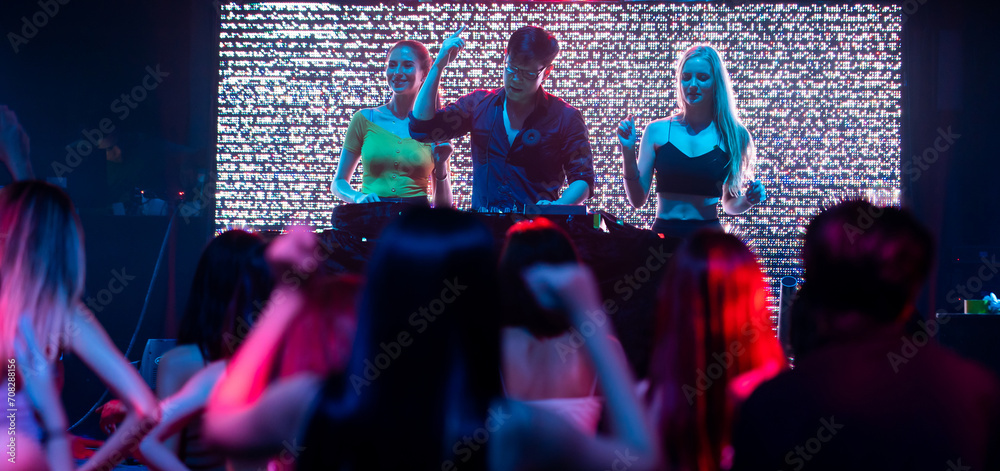 DJ with Turntables at nightclub. Group of diverse young people dancing ...