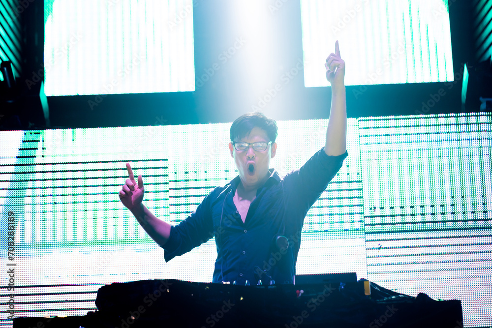 DJ with Turntables at nightclub. Group of diverse young people dancing ...